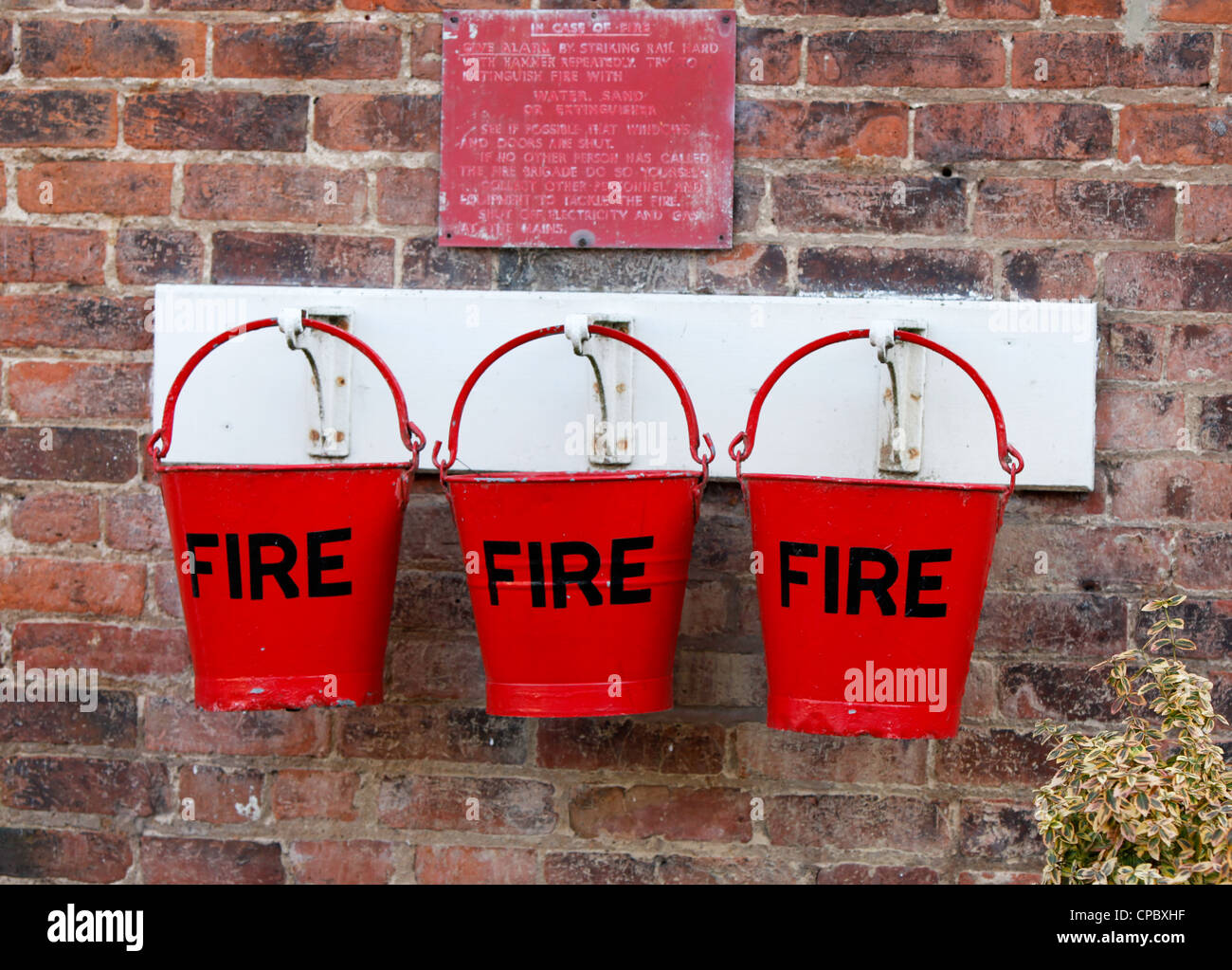 Three bright red fire buckets hanging on a brick wall Stock Photo - Alamy