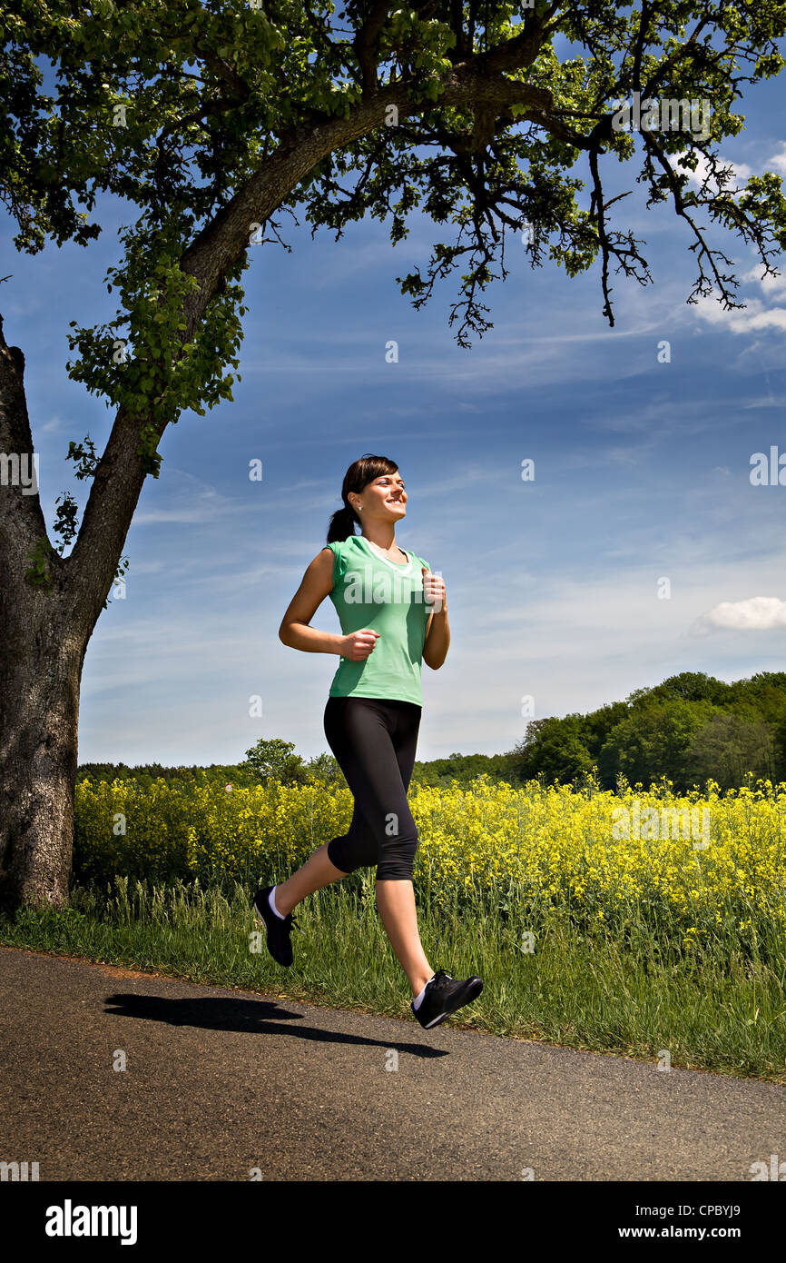 A woman jogging in front of cross country Stock Photo - Alamy