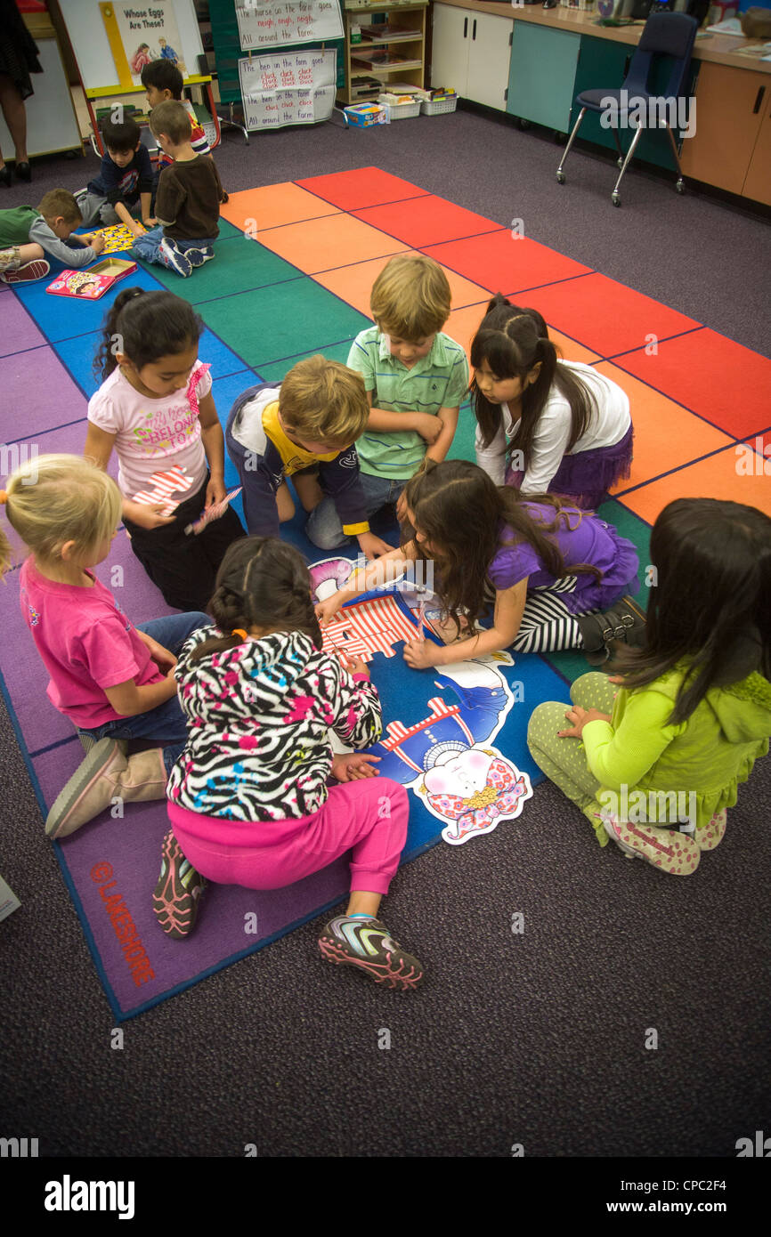 On a classroom floor, a group of kindergarten children collaborate to ...