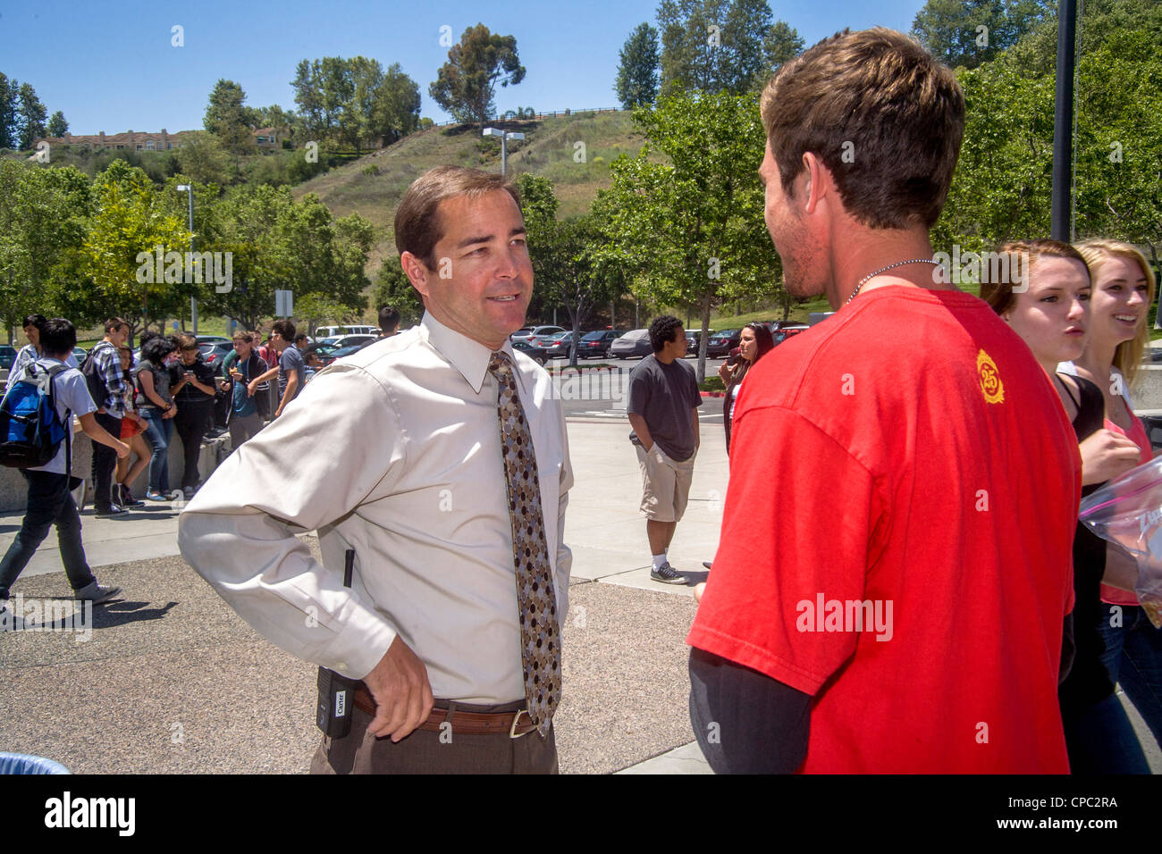 A high school principal and one of his senior students talk on the ...