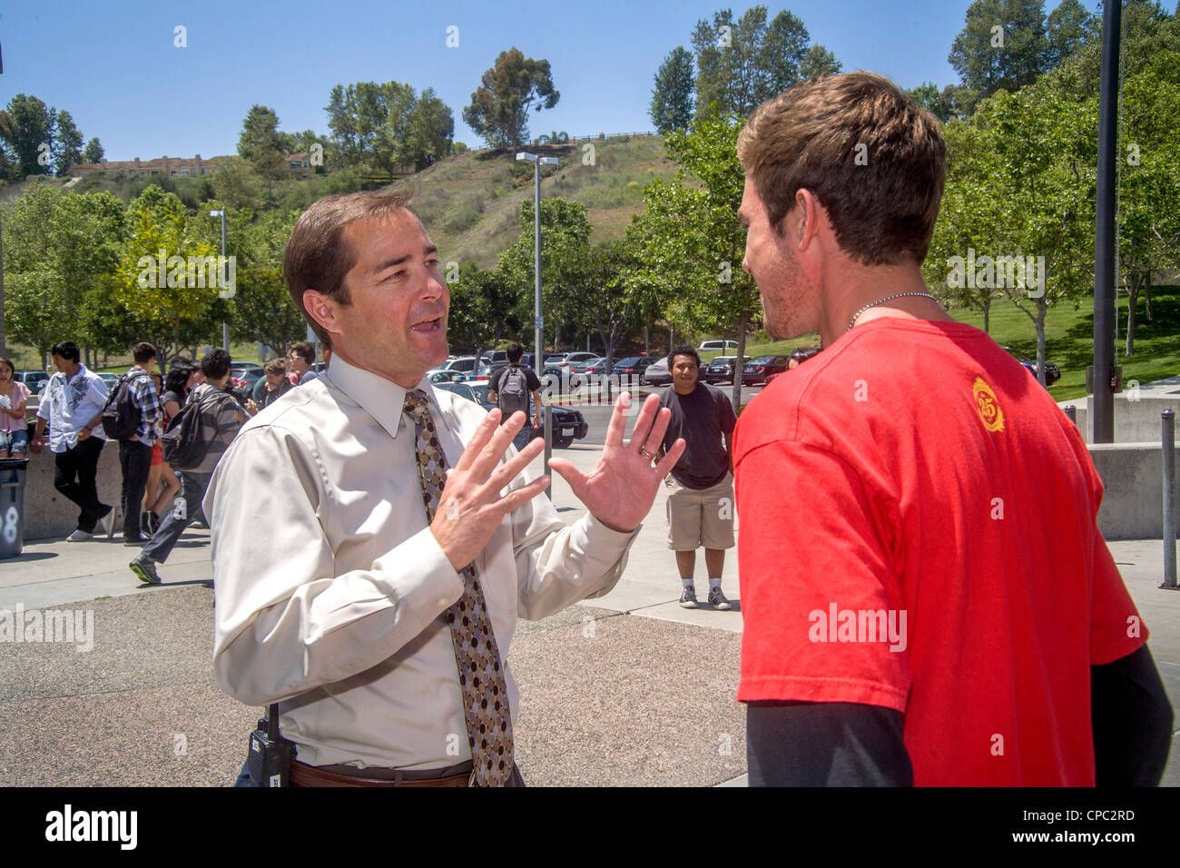 A high school principal and one of his senior students talk on the ...