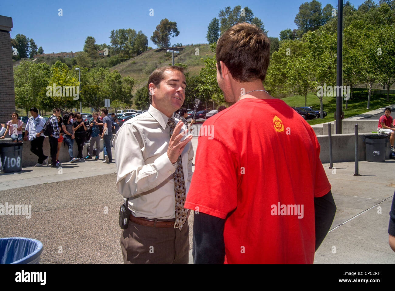 A high school principal and one of his senior students talk on the ...