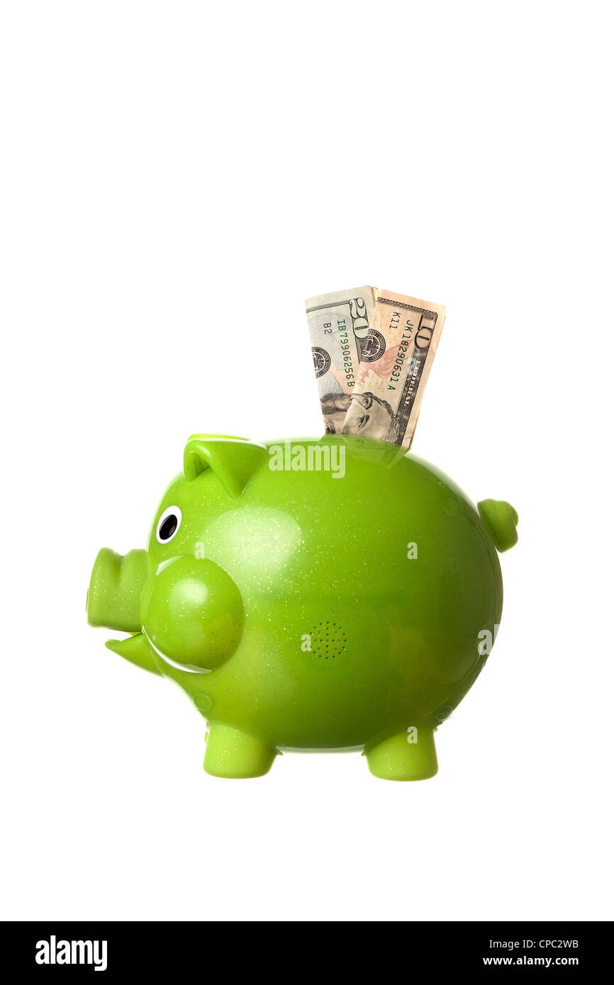 A concept image of American currency being put into a green piggy bank ...