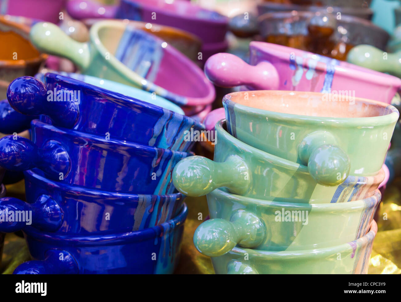 A bunch of colorful stacked ceramic bowls brightly lit Stock Photo - Alamy