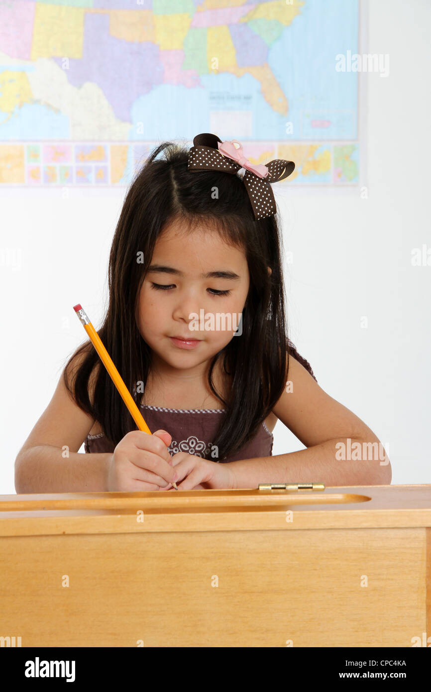 Young Girl Writing at Her Desk in School Stock Photo - Alamy