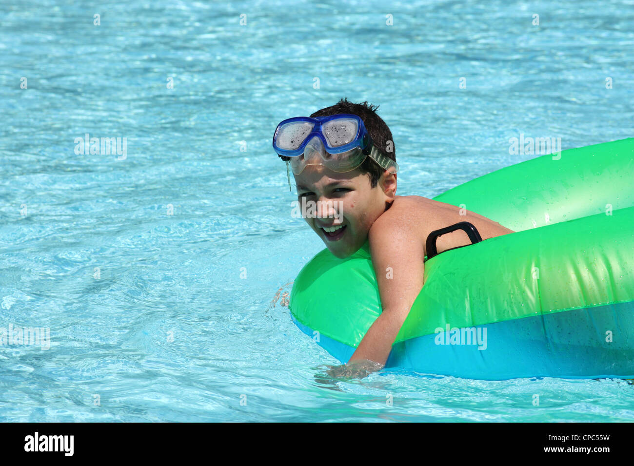 Boy in a pool floating on a tube Stock Photo - Alamy