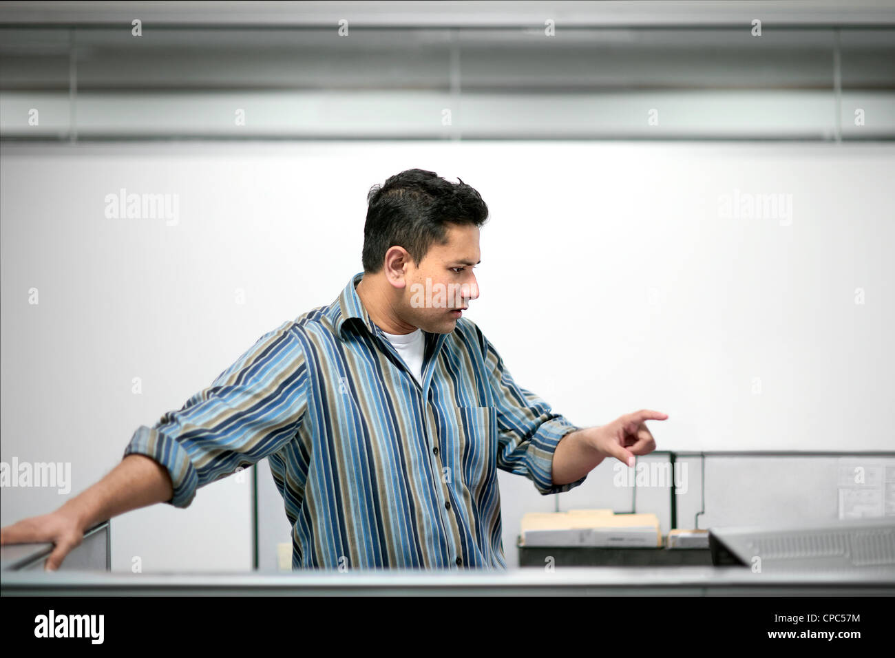A worker points his finger while standing in a cubicle Stock Photo - Alamy