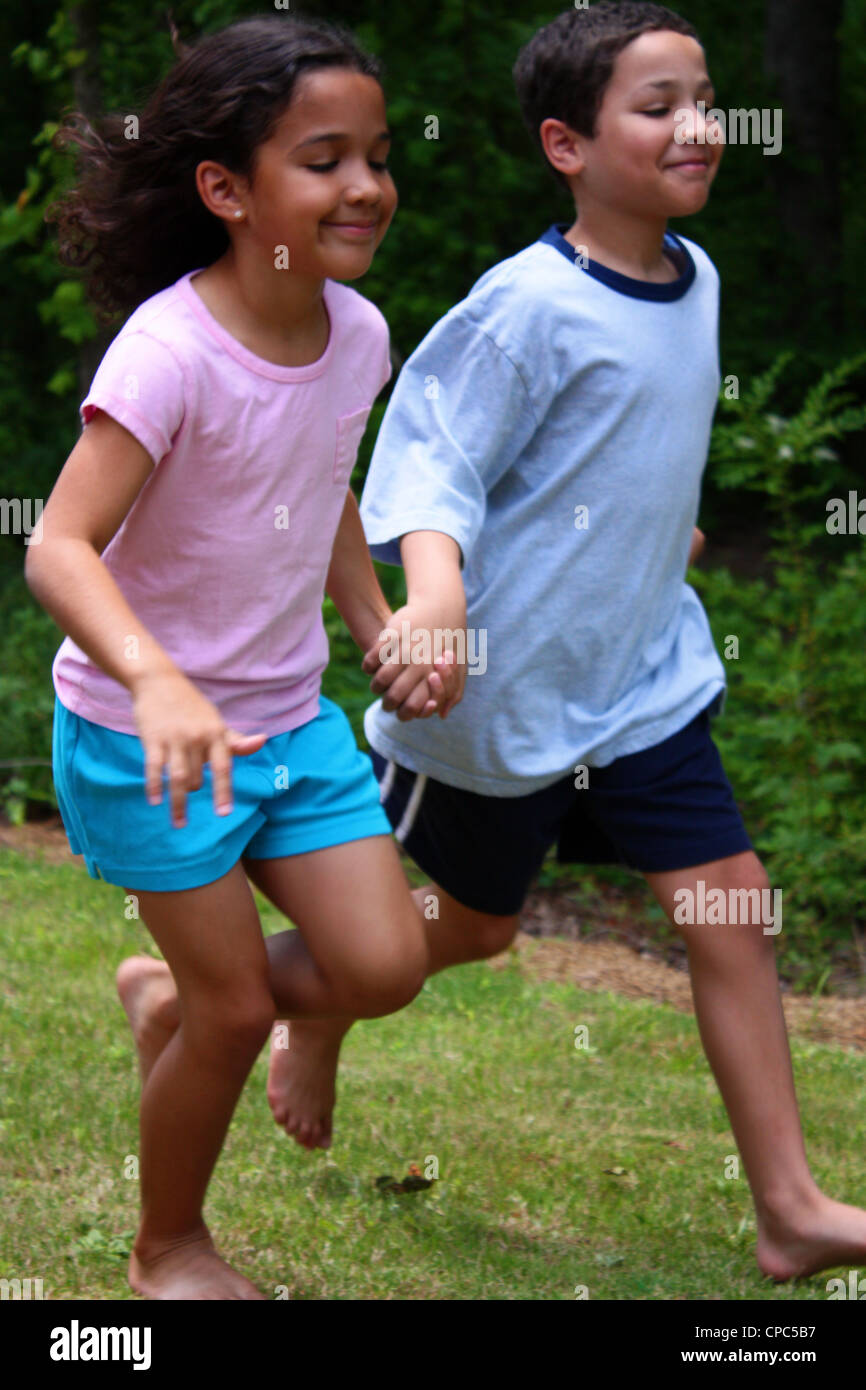 Girl and Boy running outside in the grass Stock Photo - Alamy