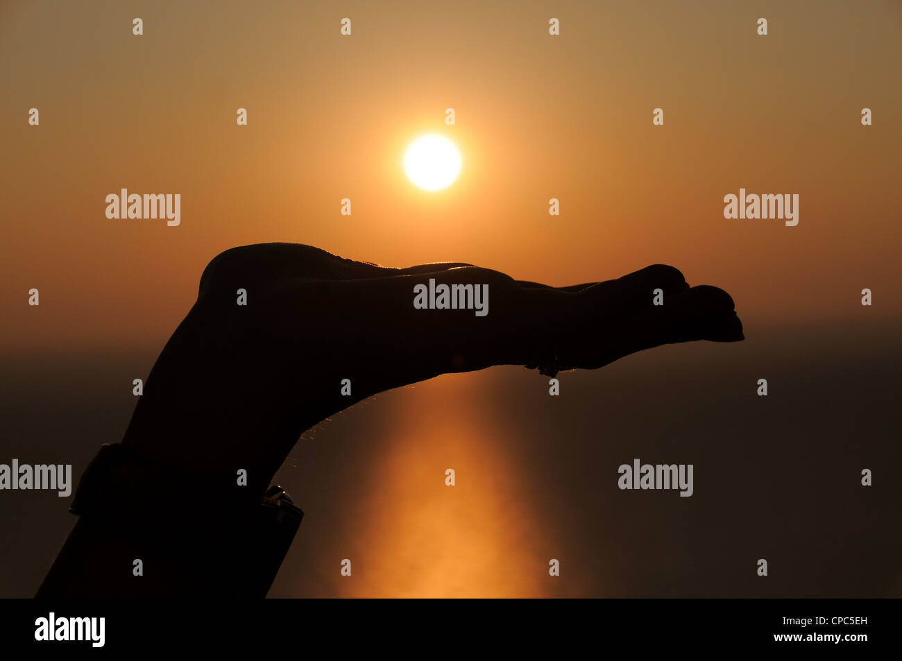 An open hand pushing the sun during sunset Stock Photo - Alamy