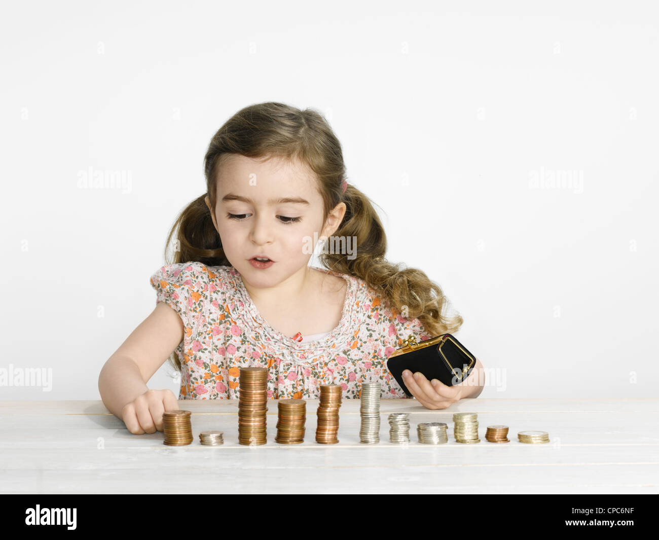 Girl stacking coins on counter Stock Photo - Alamy