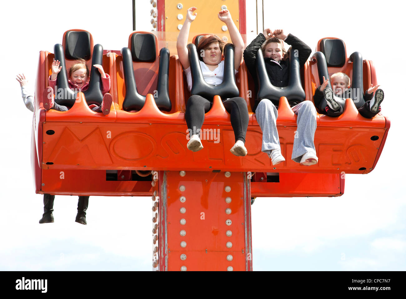 Children ride on an amusement park chair that rises and drops causing ...