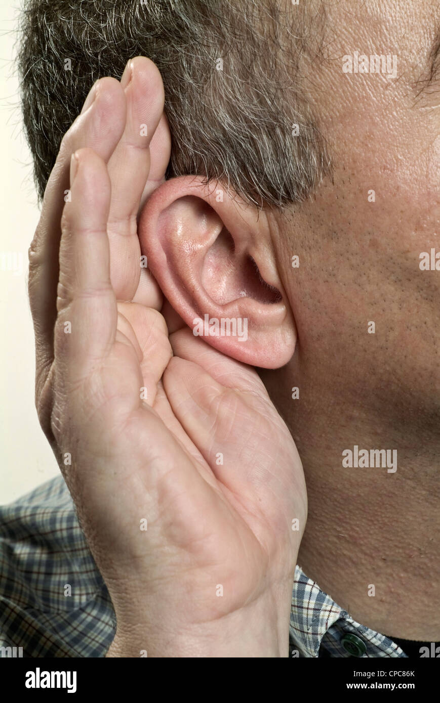 Man holding his hand to his ear, as a symbol for deafness Stock Photo ...