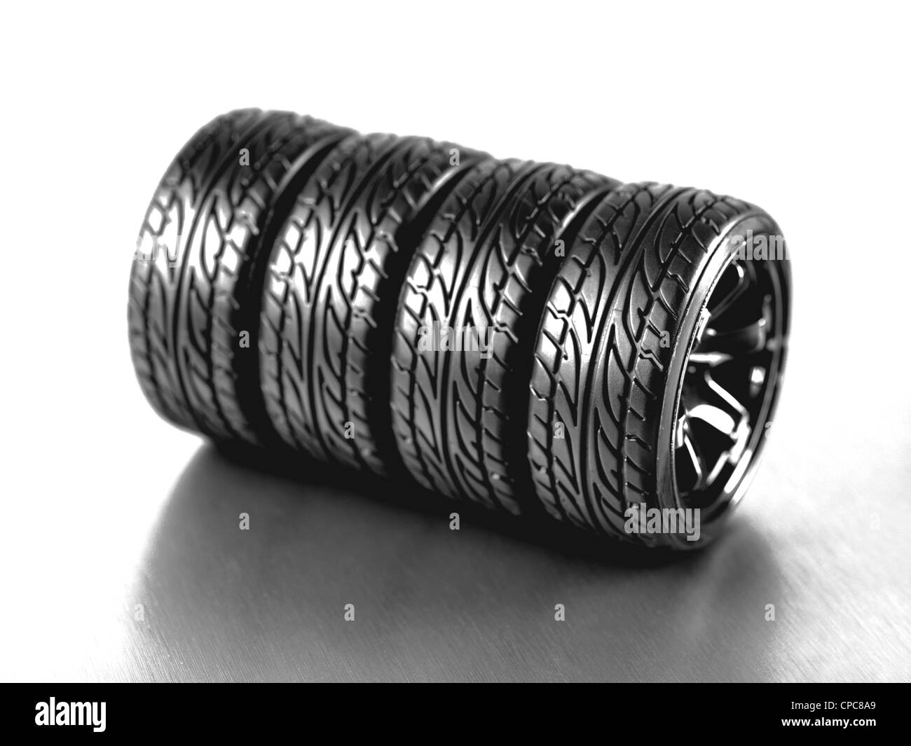 Rubber tyres with sports rims on a silver background Stock Photo - Alamy