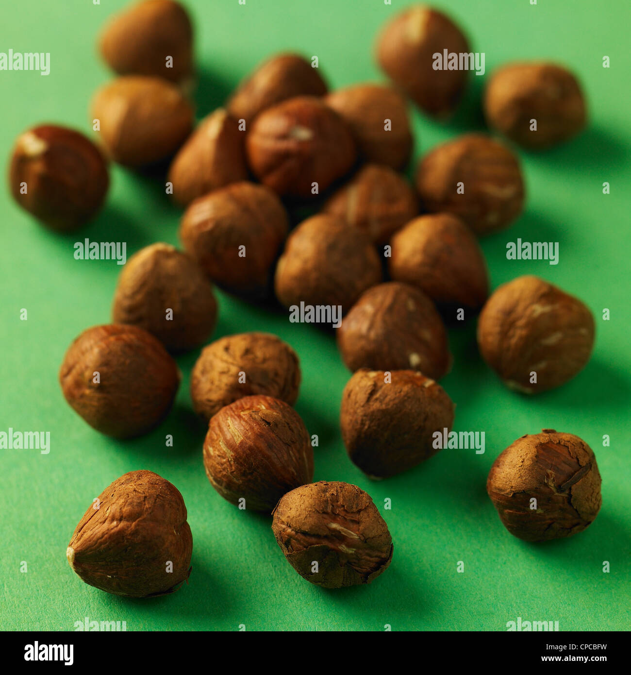 Shelled Hazelnuts on a green background Stock Photo - Alamy
