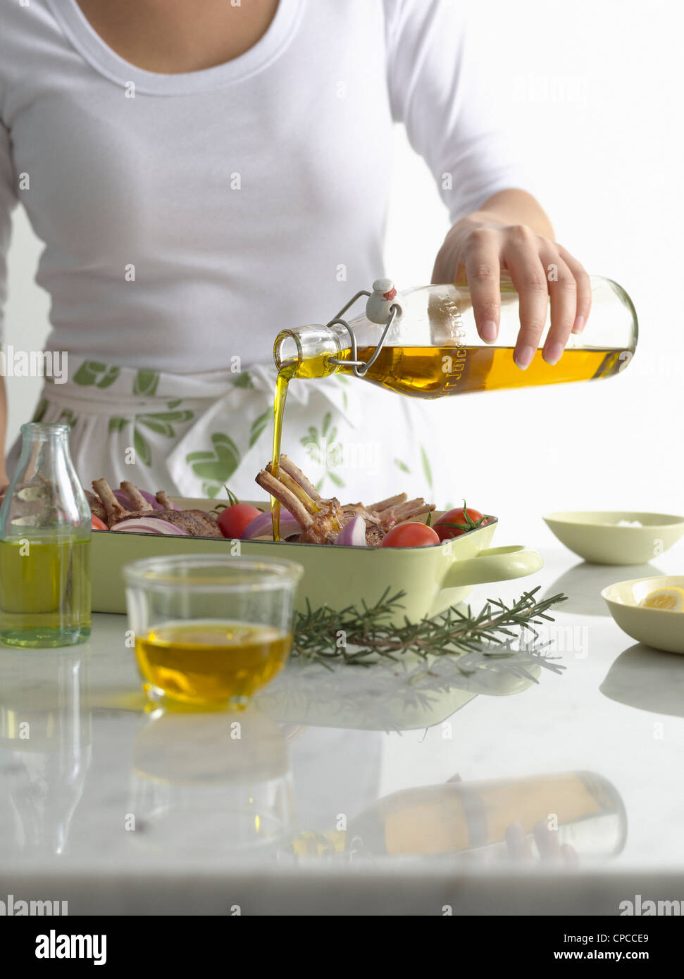 Woman pouring olive oil over roast dish Stock Photo - Alamy