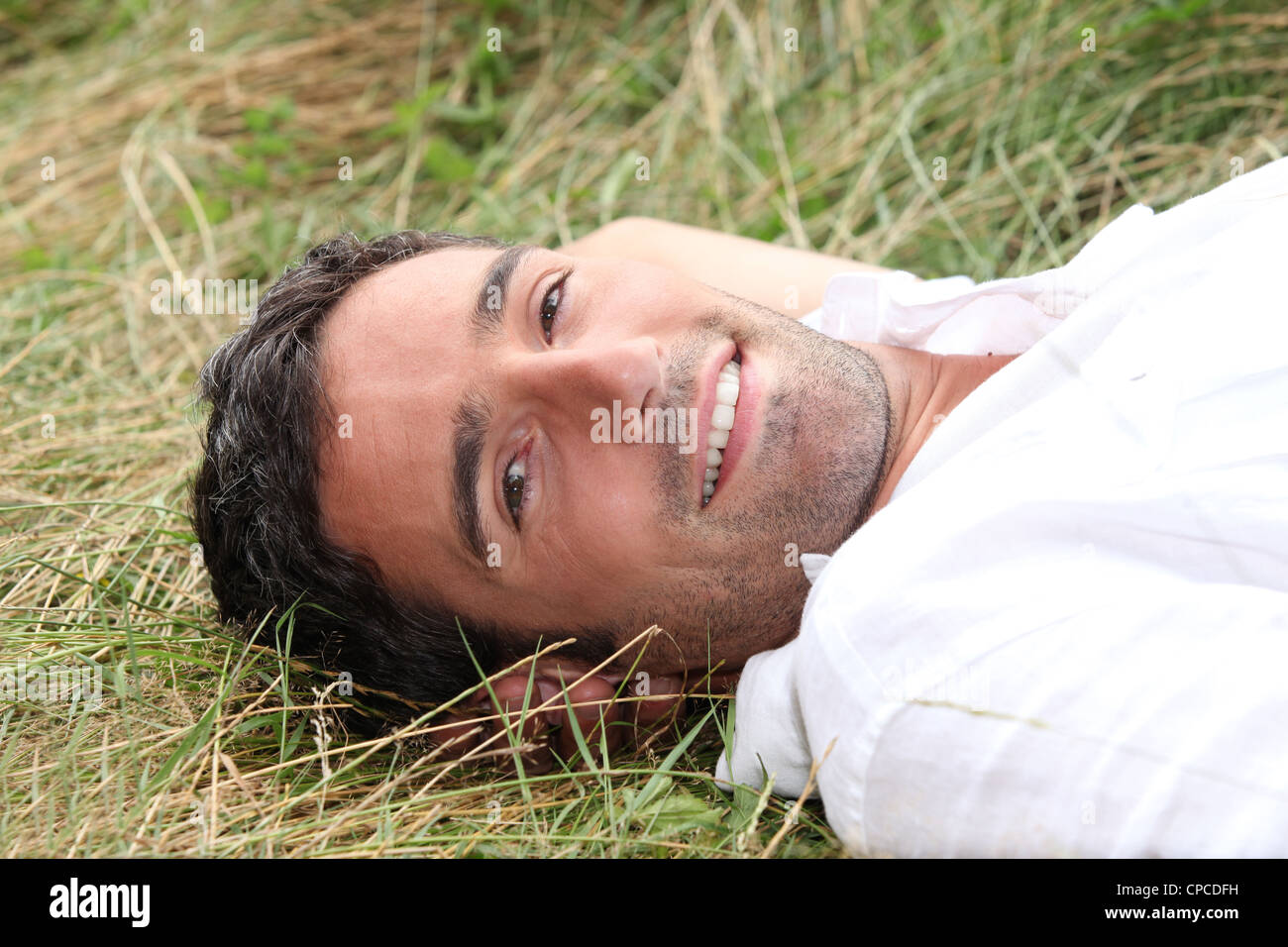 Man laying on his back in field Stock Photo - Alamy