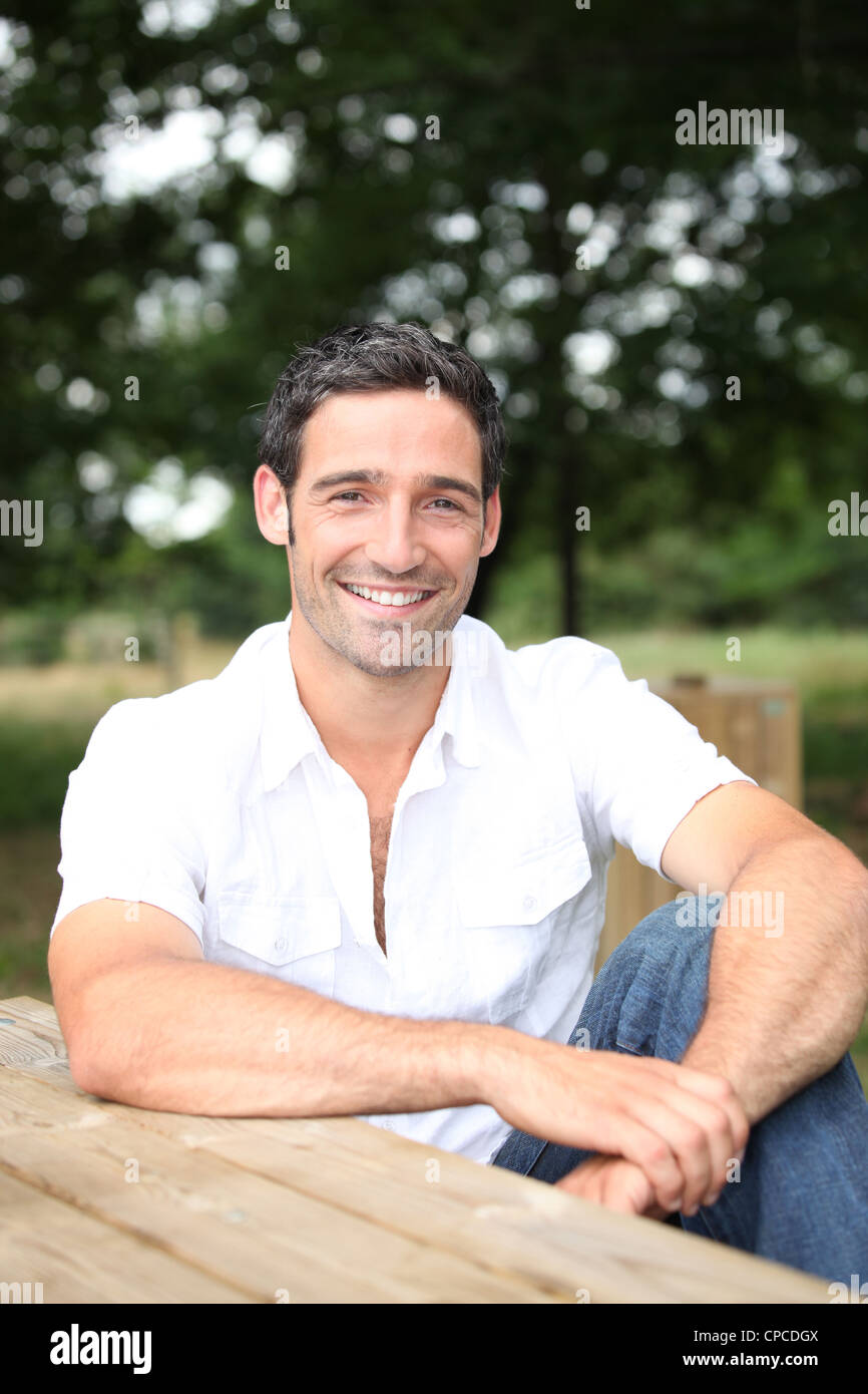 Man sat at picnic bench Stock Photo - Alamy