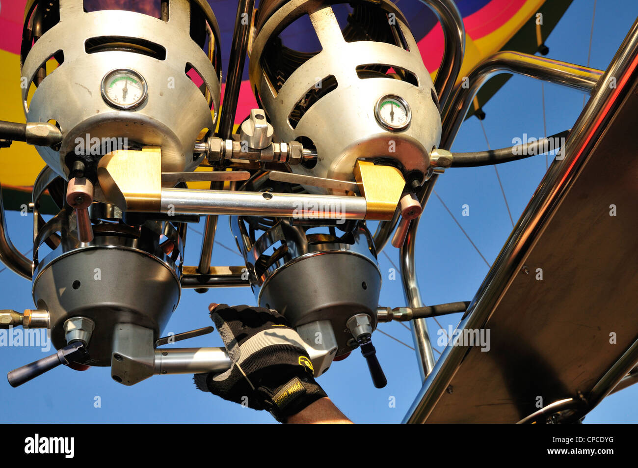 The pilot of a hot air balloon reaches for a burner's control lever ...
