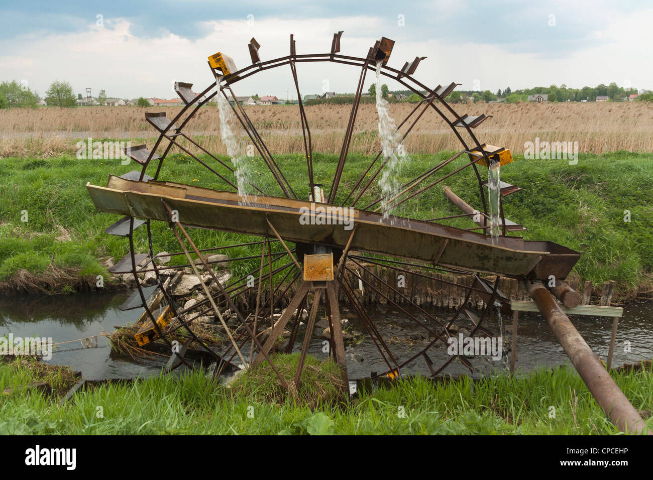 Wheel supplying water from small river into ponds located nearby Stock ...