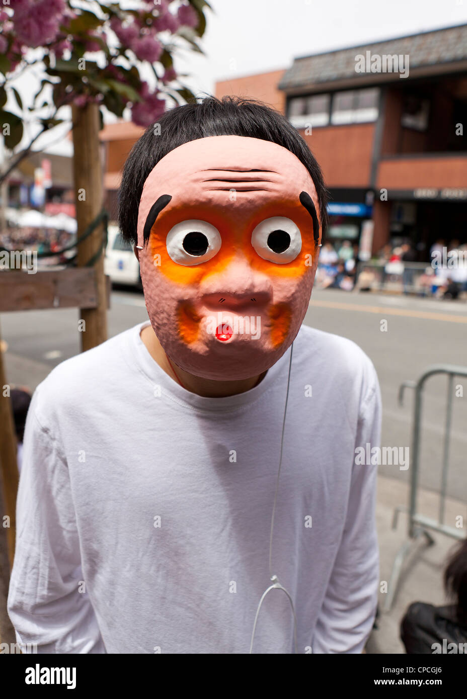 A young man wearing a Japanese Hyottoko mask Stock Photo - Alamy