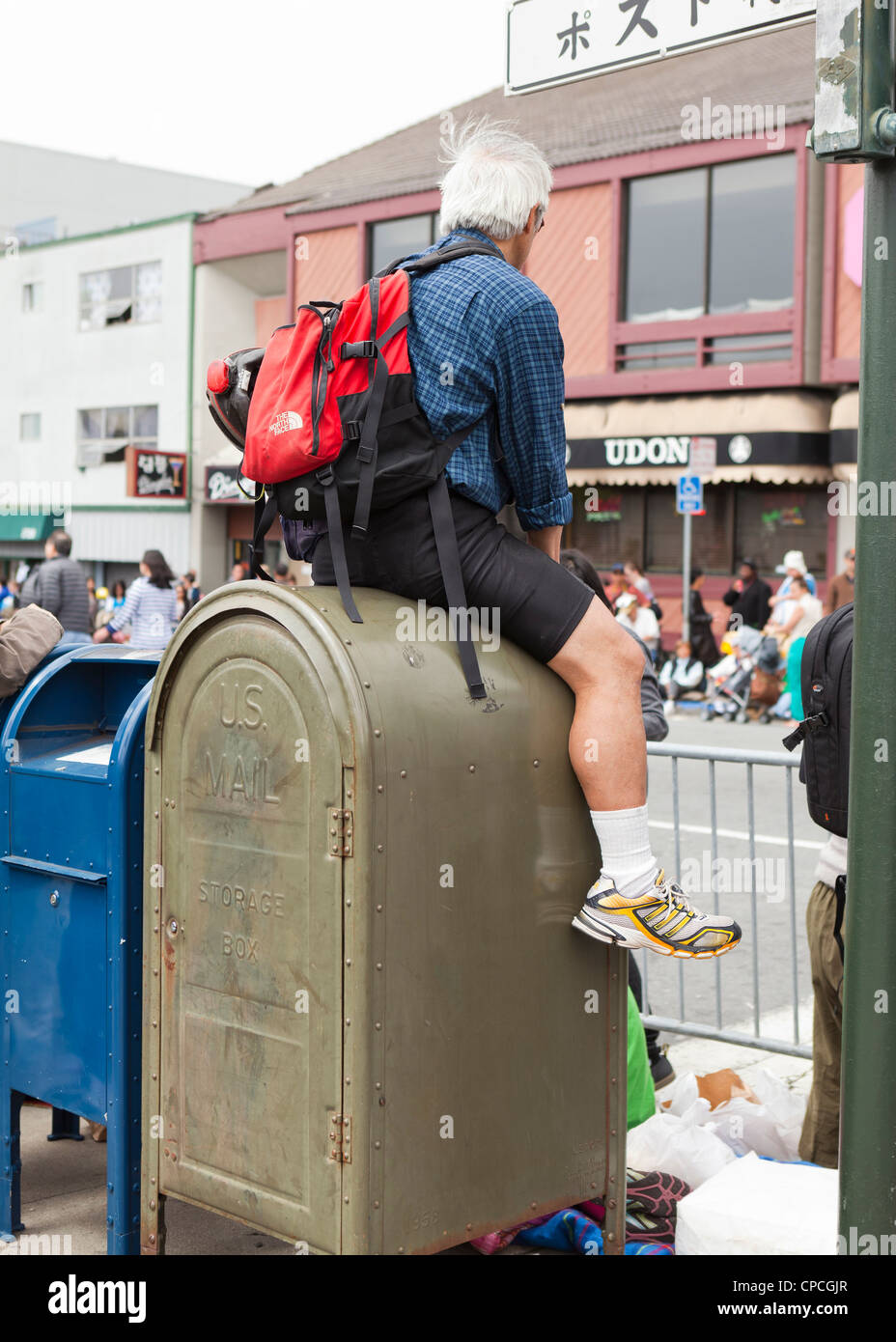 A man sitting on a mailbox Stock Photo - Alamy