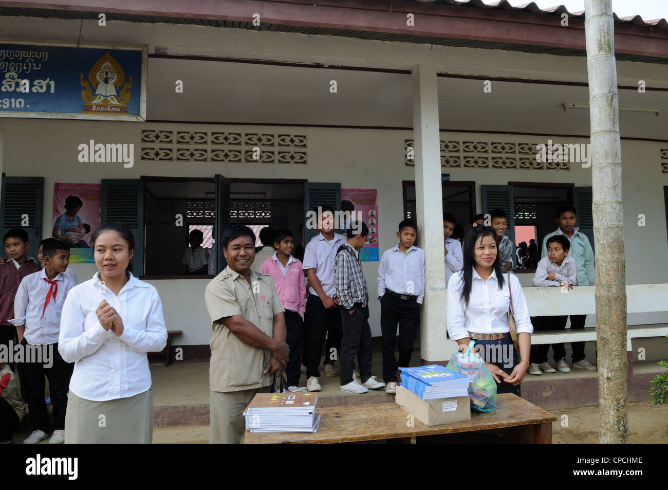 Lao teachers being presented with books and stationary at a school in ...