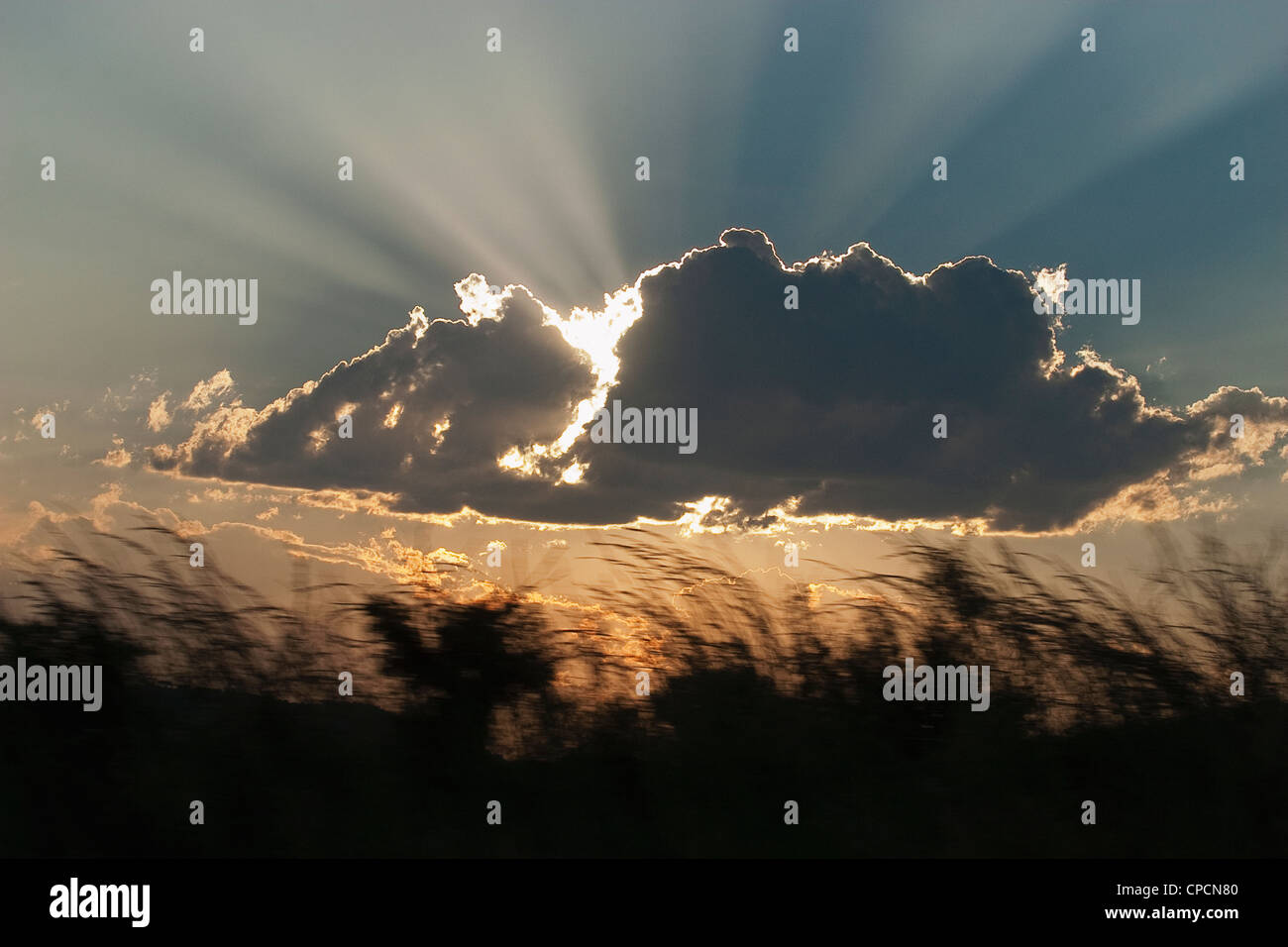 Sun shining through clouds Stock Photo - Alamy
