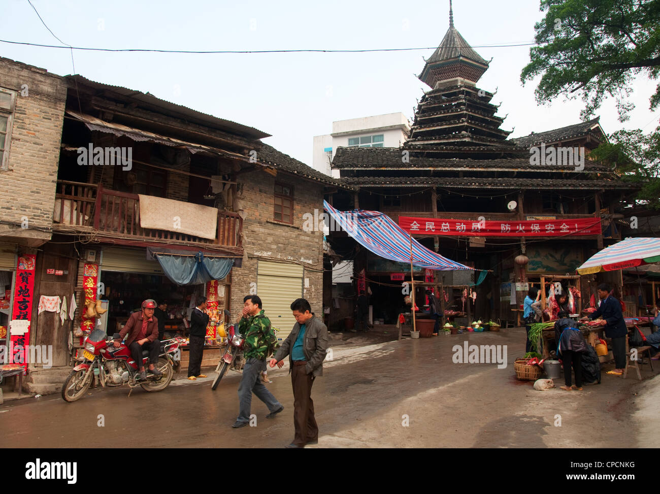 People and stalls in the street in front of the old Drum Tower of ...