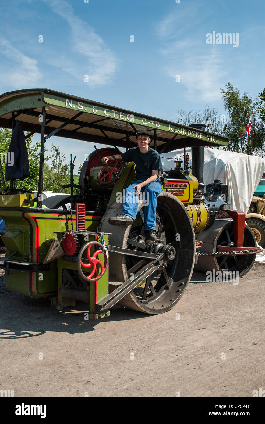 Engine driver sitting on big rear wheel of steam engine Stock Photo - Alamy