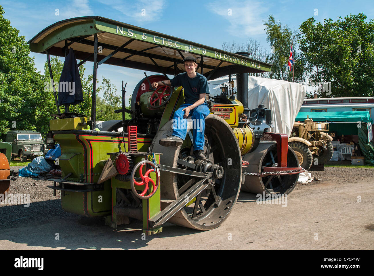 Engine driver sitting on big rear wheel of steam engine Stock Photo - Alamy