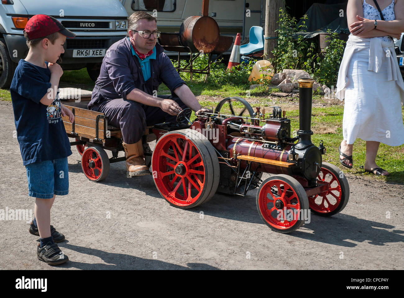 Man drives minature steam engine, young boys looks on Stock Photo - Alamy
