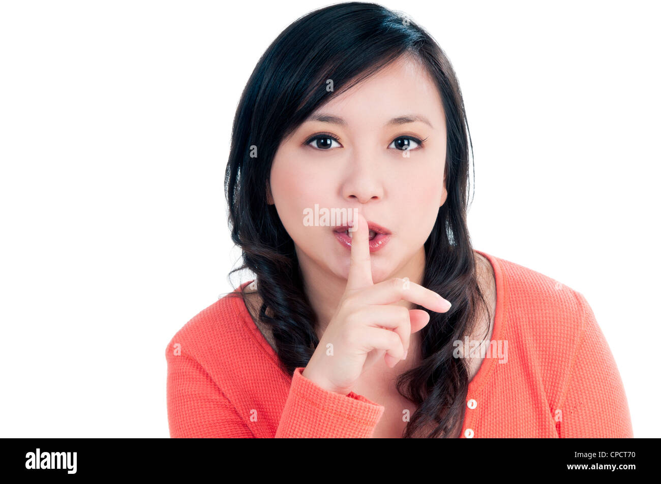 Attractive young woman showing finger over her lips Stock Photo - Alamy