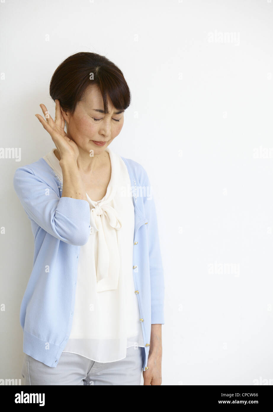 Senior woman with hand on ear Stock Photo - Alamy