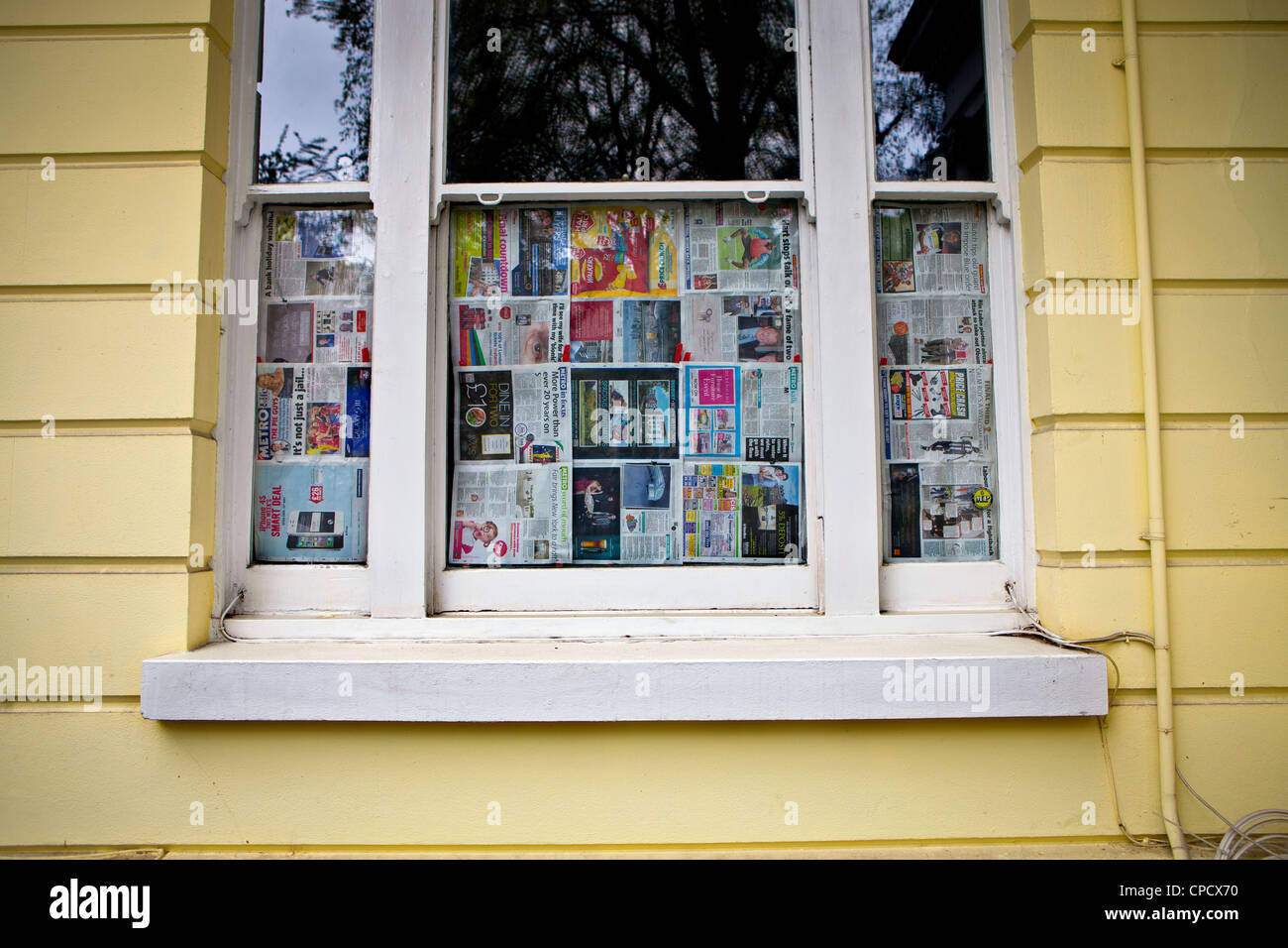 Pages of newspaper covering residential window Stock Photo - Alamy