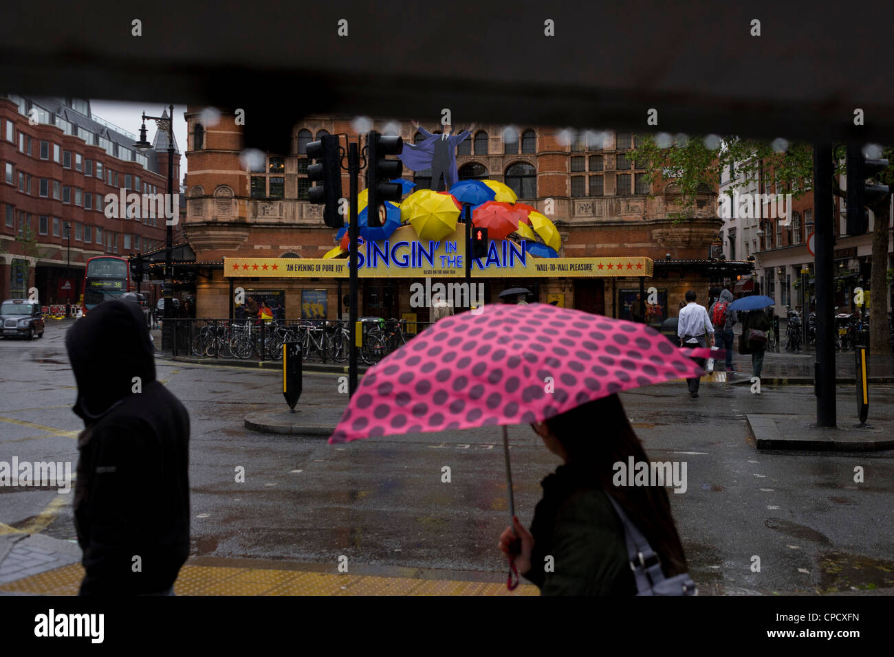 On a rainy day, pedestrians hurry past during a shower outside where ...