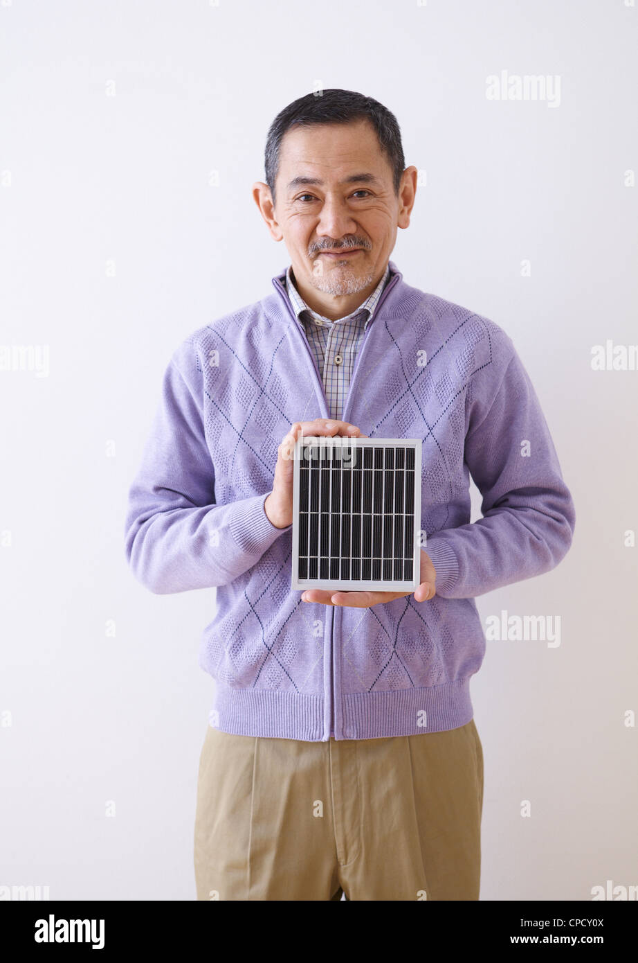 Senior man holding solar panel Stock Photo - Alamy