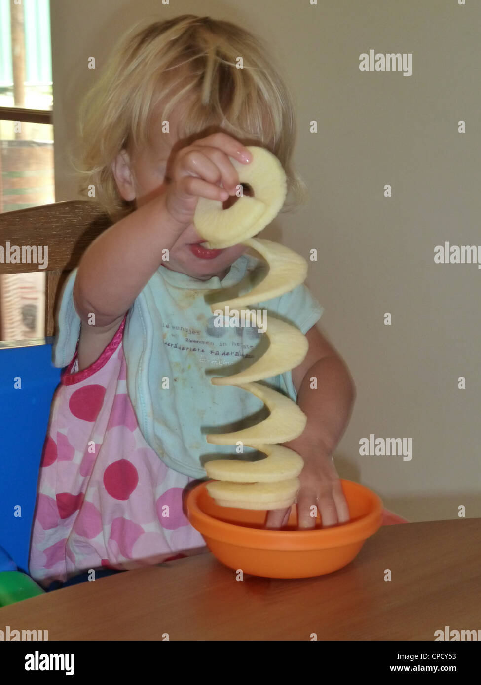Toddler eats curly cut apple Stock Photo - Alamy