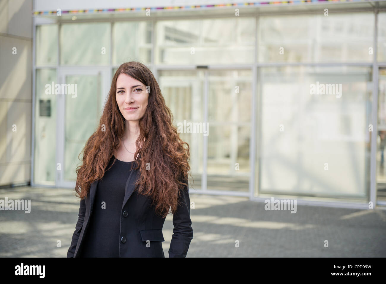 Young smiling business woman - portrait on building glass background ... Young smiling business woman - portrait on building glass background ...