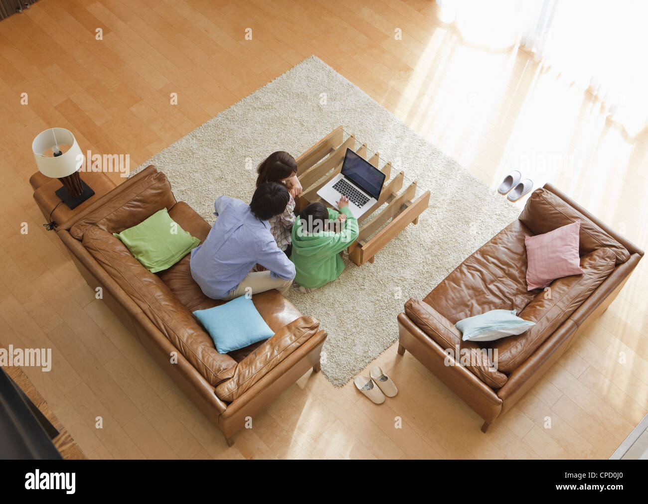 Family looking at laptop in a living room Stock Photo - Alamy