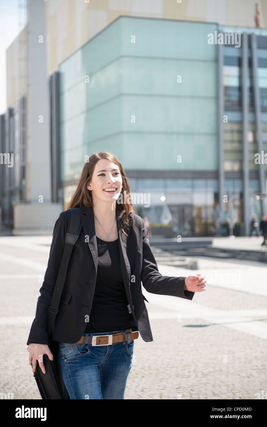 Young smiling woman in hurry - walking street with notebook bag Stock ...
