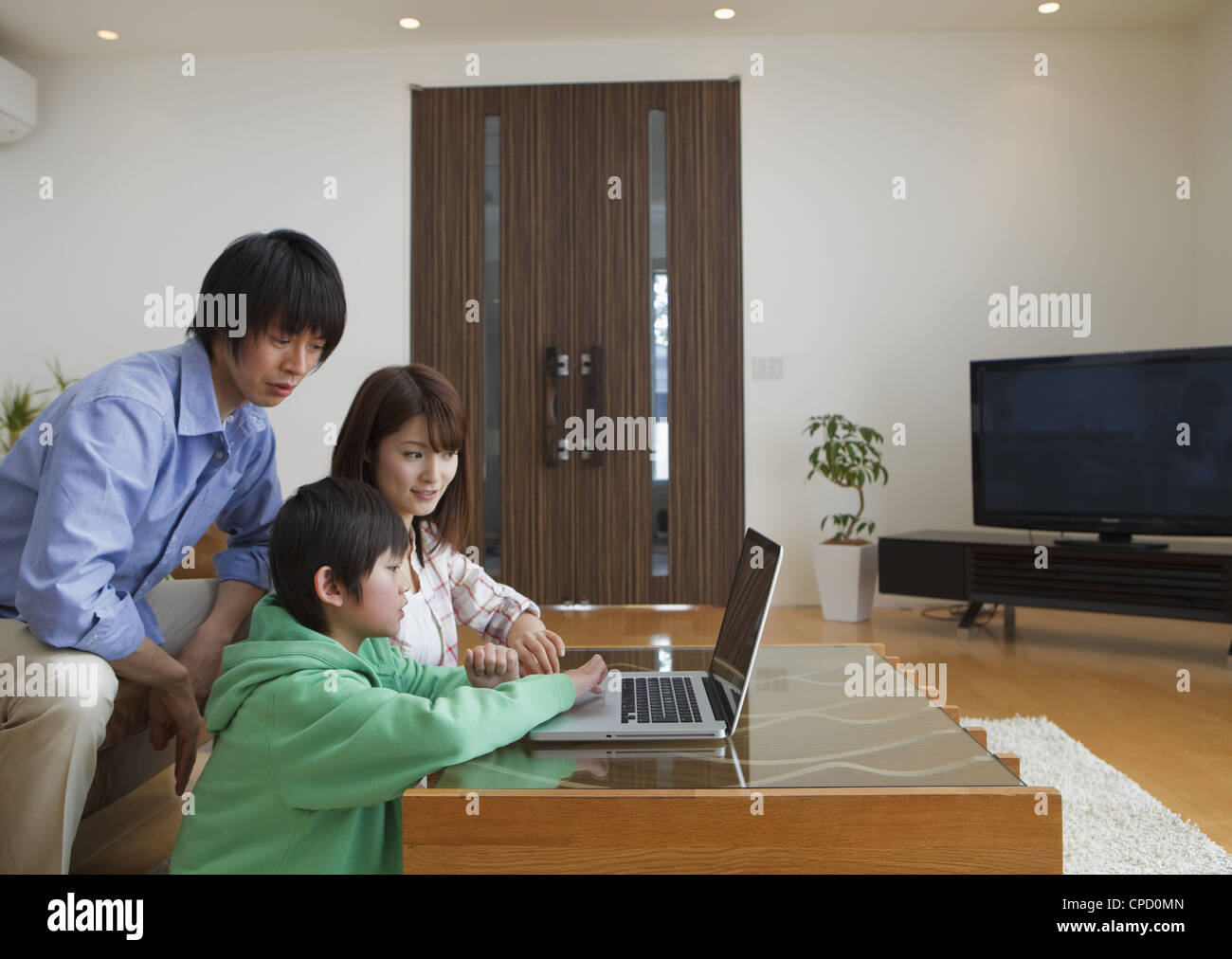 Family looking at laptop Stock Photo - Alamy