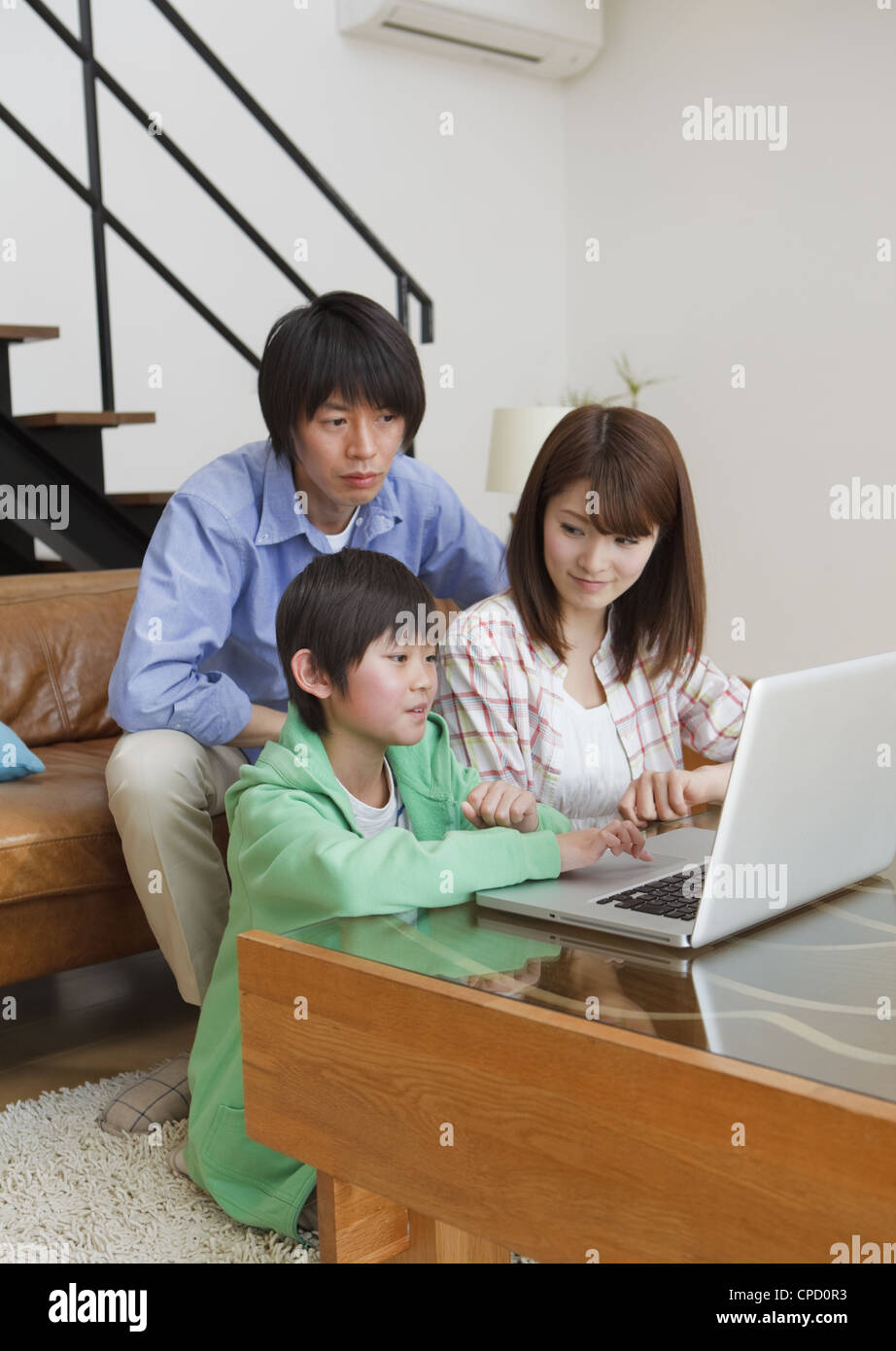 Family looking at laptop Stock Photo - Alamy