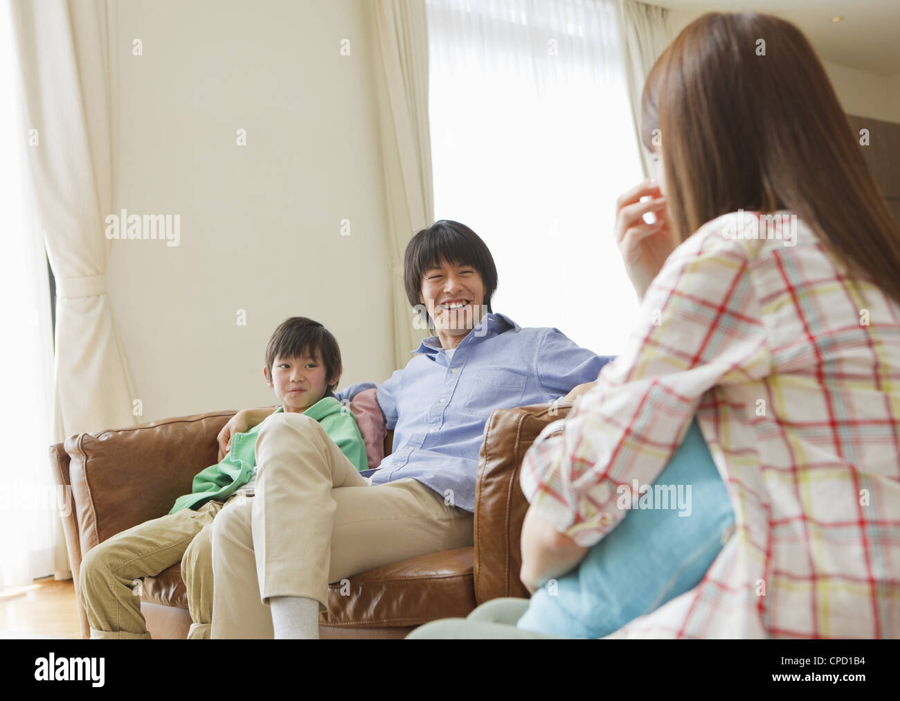 Family relaxing in a living room Stock Photo - Alamy