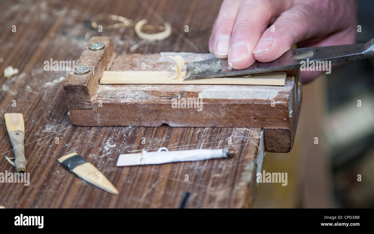 Uilleann pipe maker Michael Vignoles cutting a reed in his workshop ...