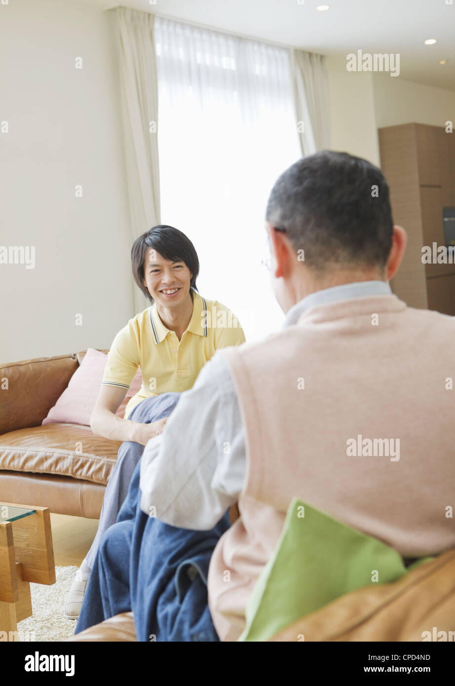 Two men chatting in a living room Stock Photo - Alamy