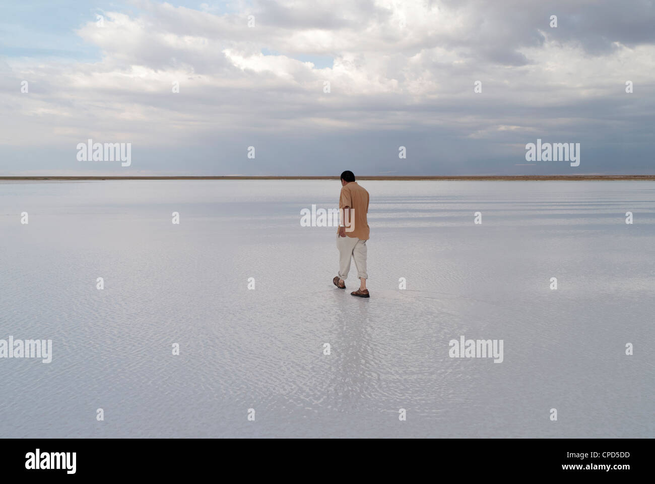 Man walking the salt flats of Atacama Stock Photo - Alamy