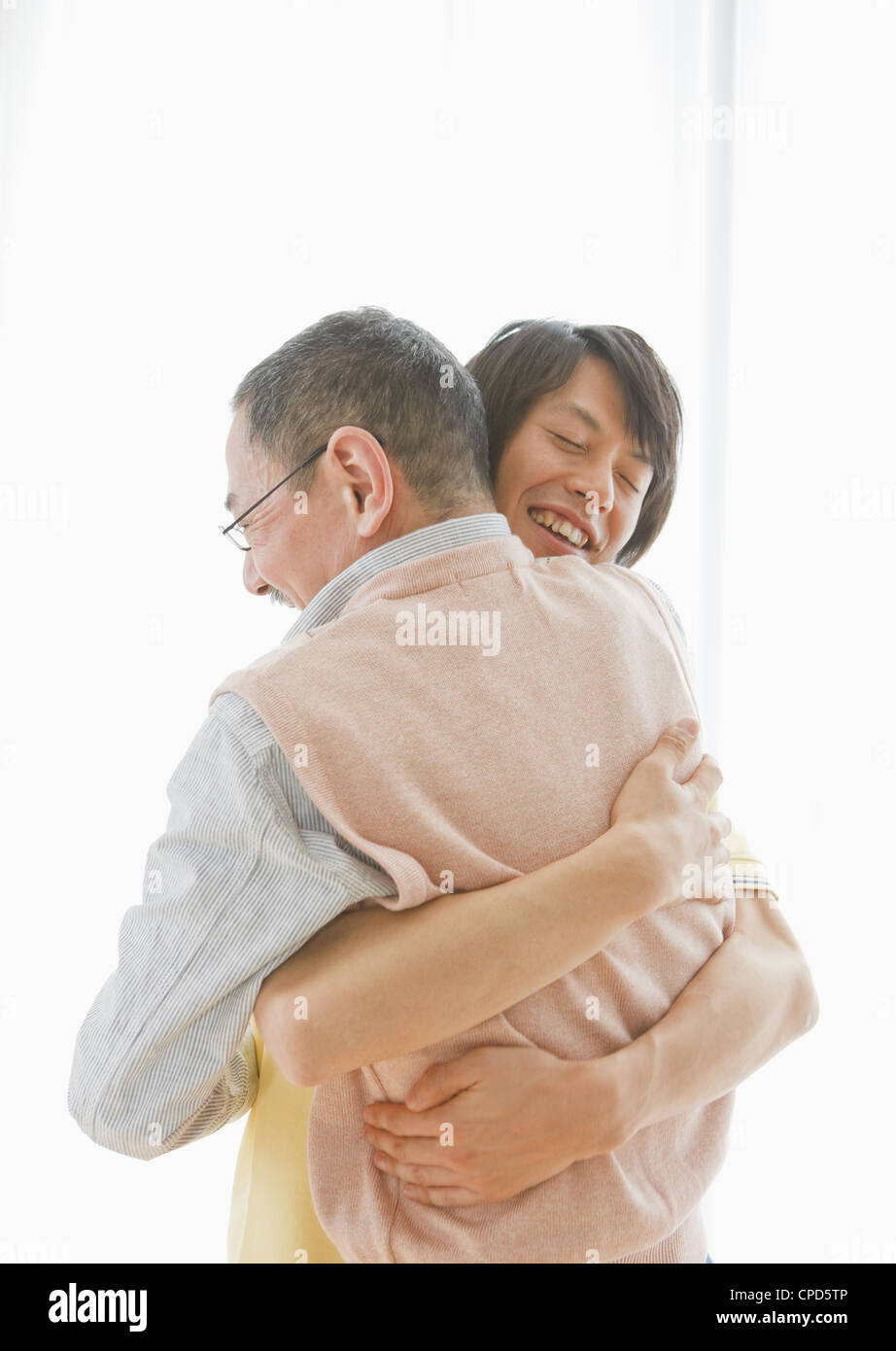 Middle-aged man and senior man hugging each other Stock Photo - Alamy