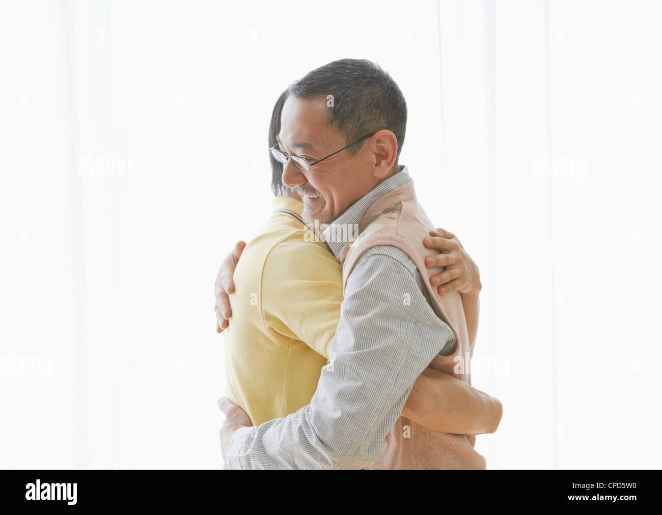 Middle-aged man and senior man hugging each other Stock Photo - Alamy