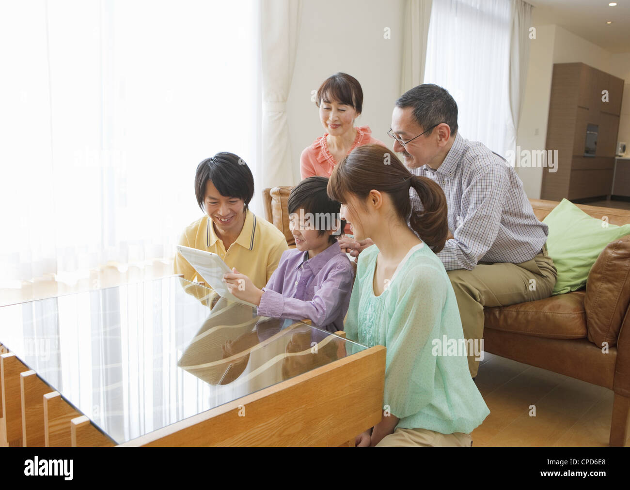 Three-generation family looking at tablet PC Stock Photo - Alamy