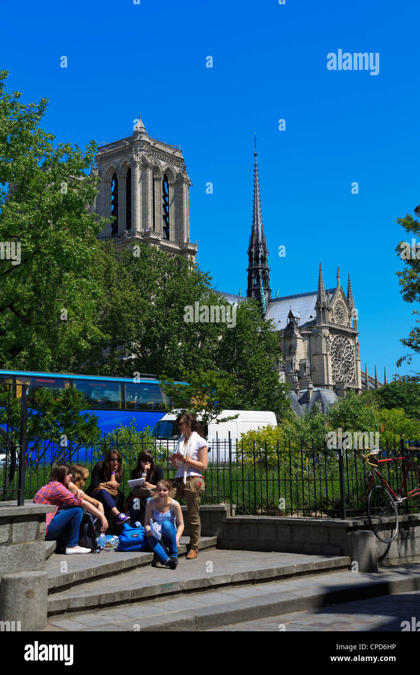 Students sitting on steps on the Left Bank with Notre Dame in the ...